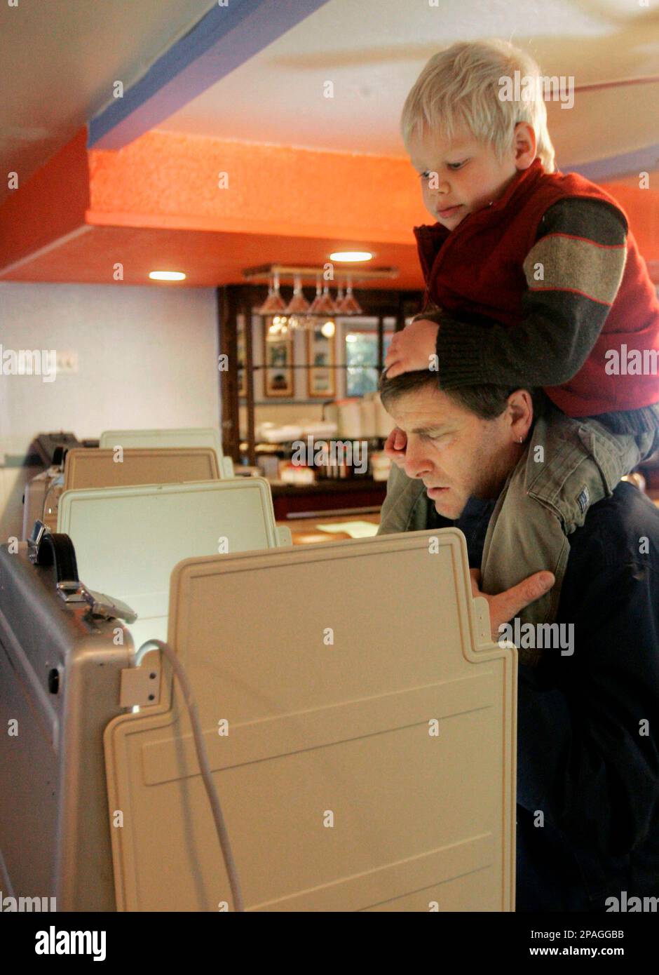 Ken Neill votes in the California primary as his son Ryland, 3, sits on ...