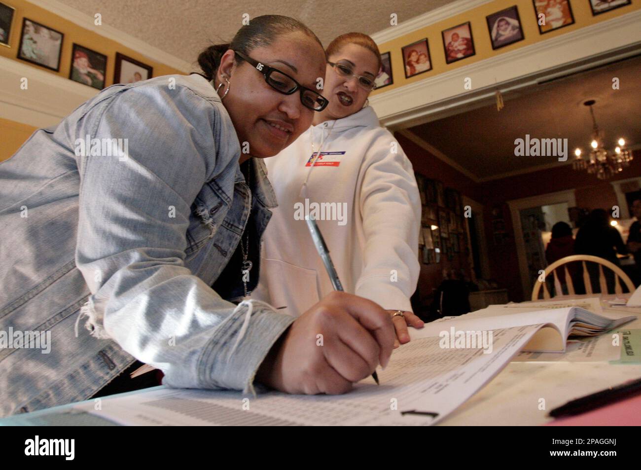 Tekeisha Tillis, left, signs in to vote as Lisa Carmona provides ...
