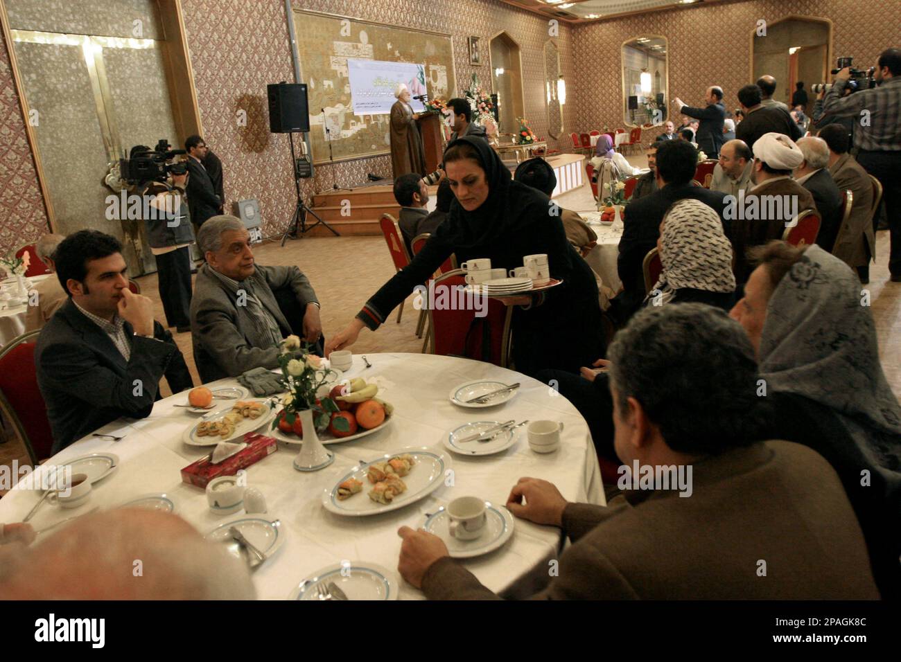 An Iranian Muslim female worker serves tea to Iranian Jewish Committee ...