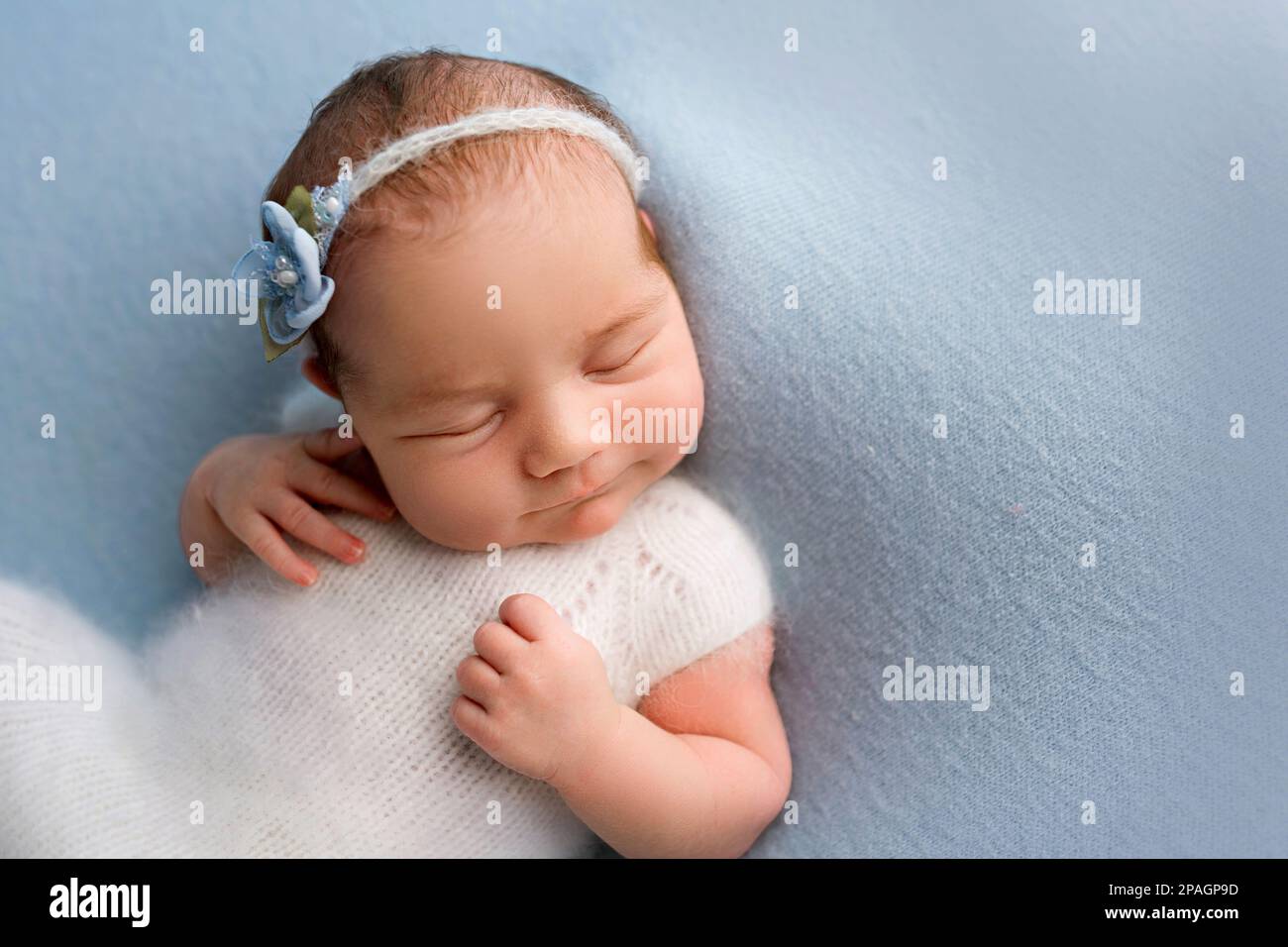 Top view of a newborn baby girl sleeping in a white bodysuit with a blue bandage Stock Photo - Alamy