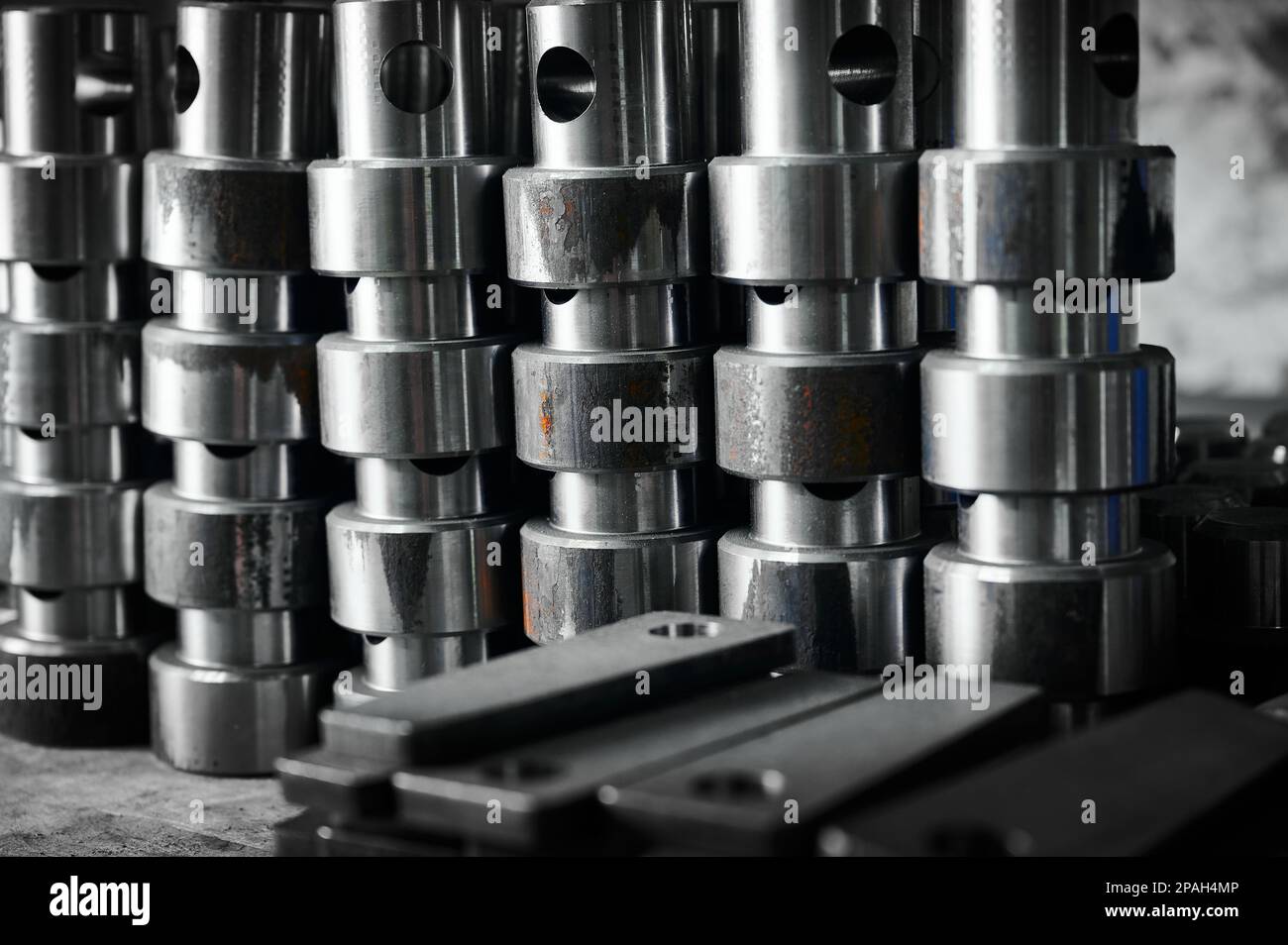 Stacks of steel rollers with holes in plant warehouse Stock Photo - Alamy