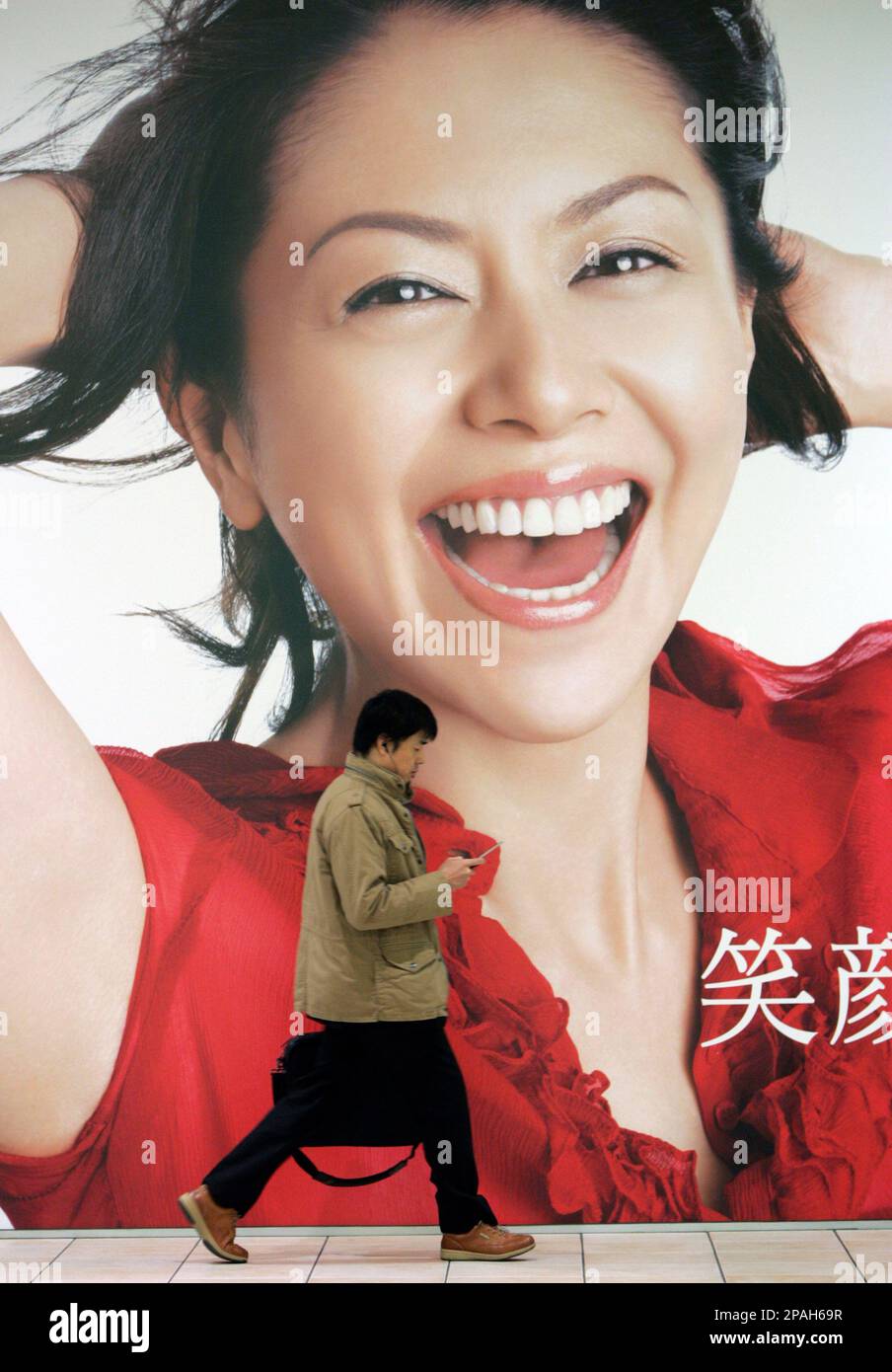 A man walks past a huge billboard featuring Japanese actress Kyoko ...