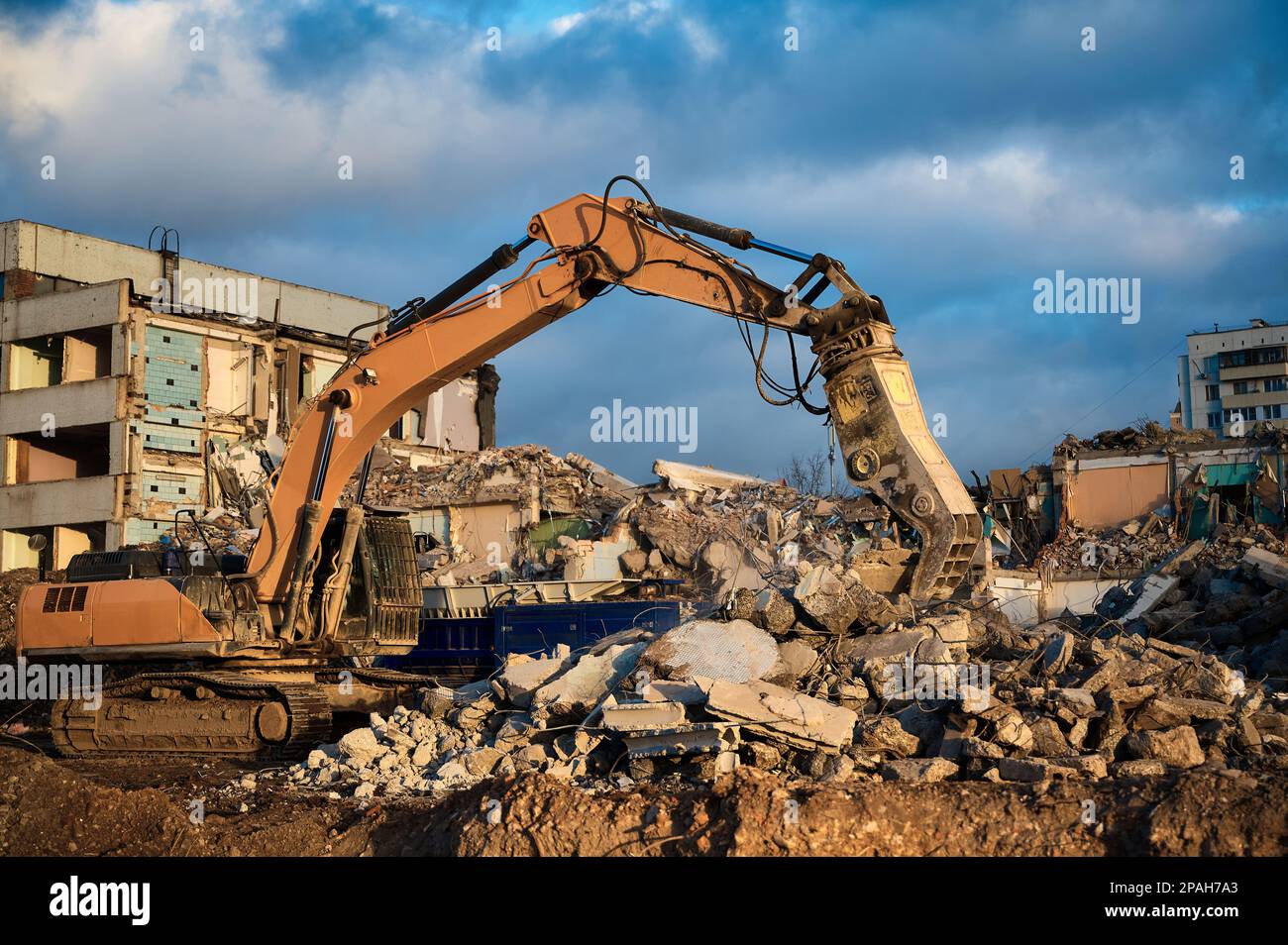 Excavator with concrete crusher at demolition site Stock Photo - Alamy