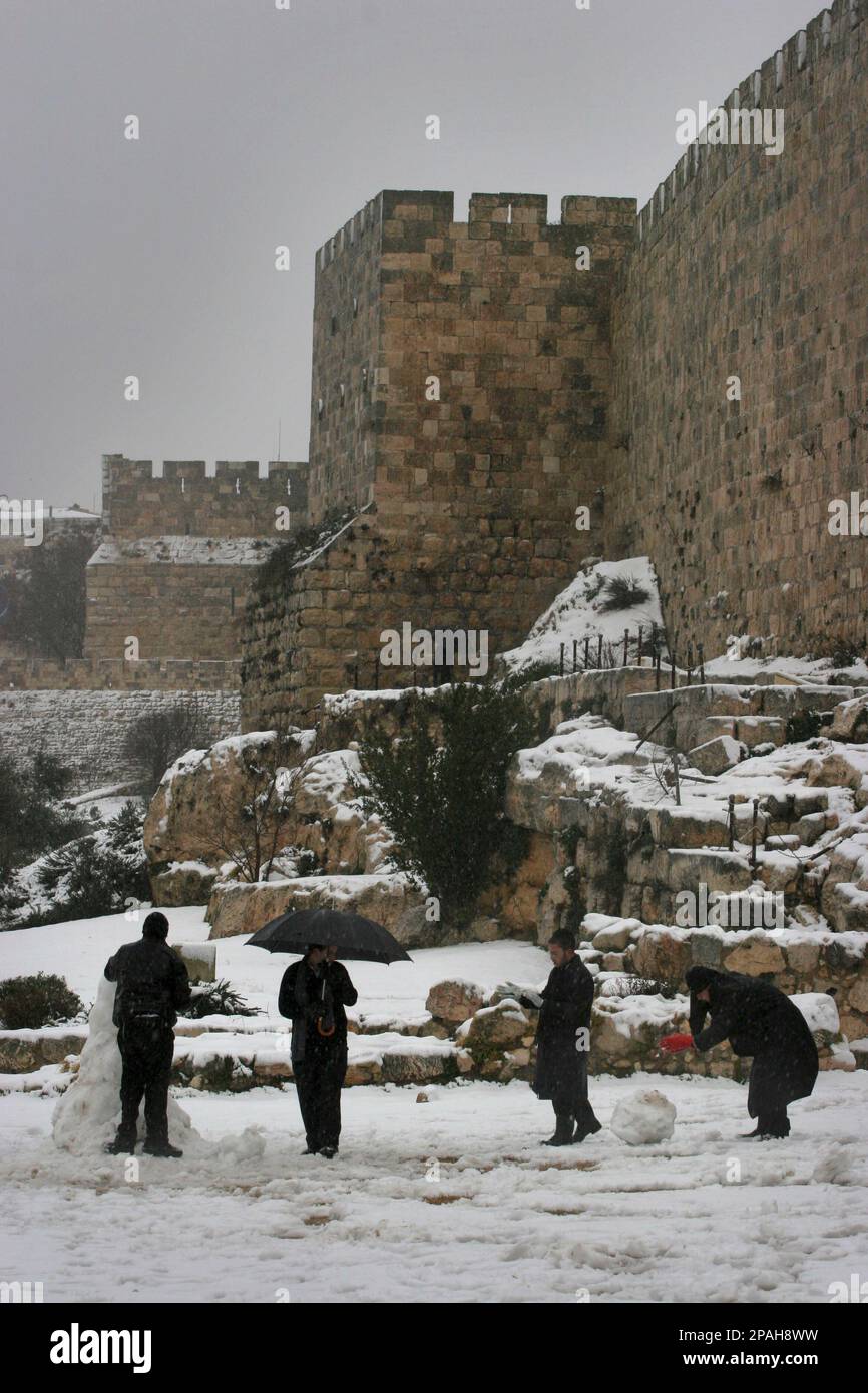 Ultra-Orthodox Jewish men build a snowman outside Jerusalem's Old City ...