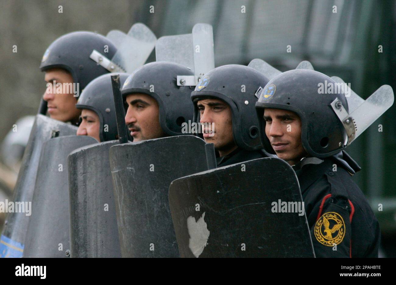 Members of the Egyptian forces stand guard on the breached border wall ...