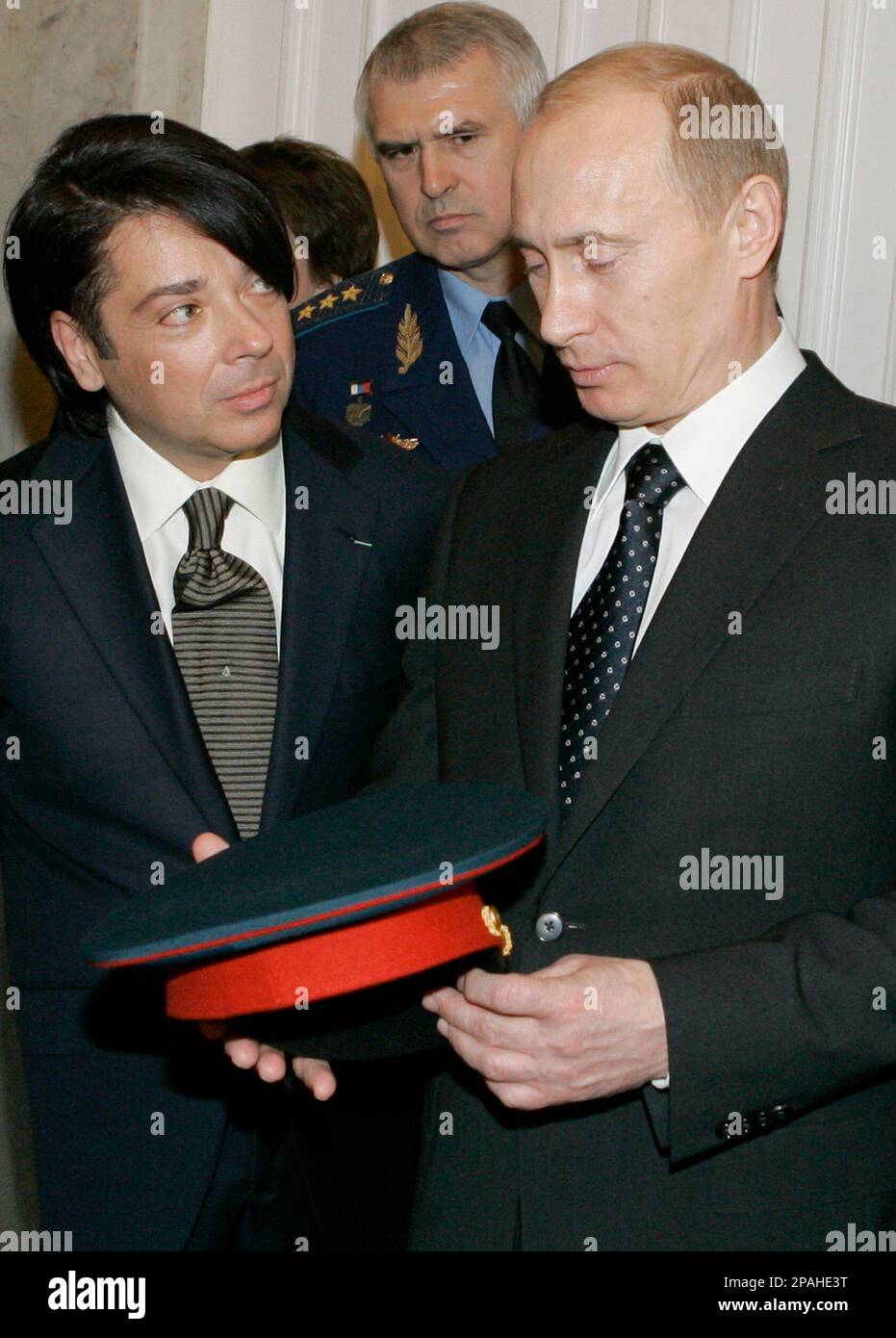 President Vladimir Putin, right, holds a new style service cap during a ...