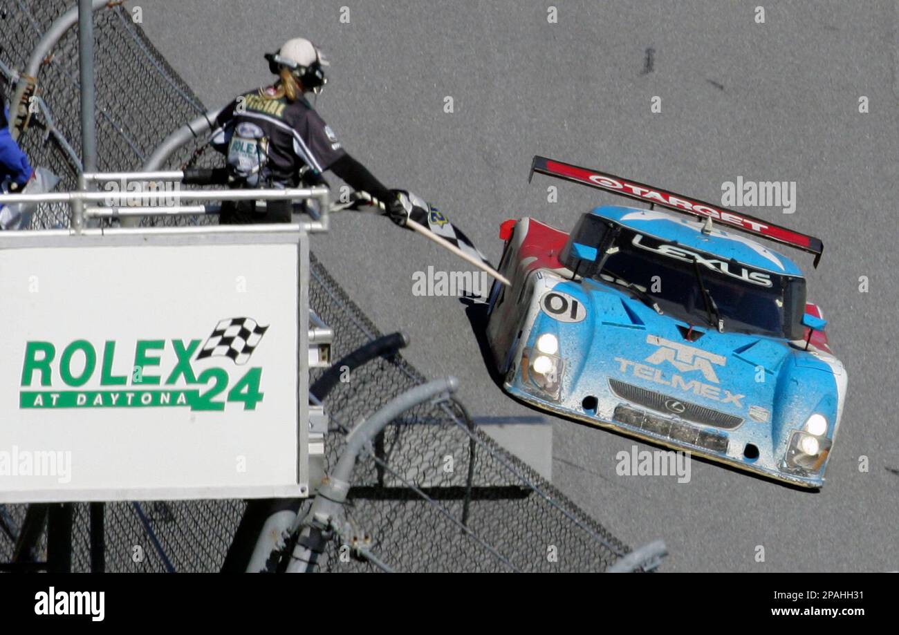 Scott Pruett drives the No. 01 Lexus Riley past the checkered flag to ...