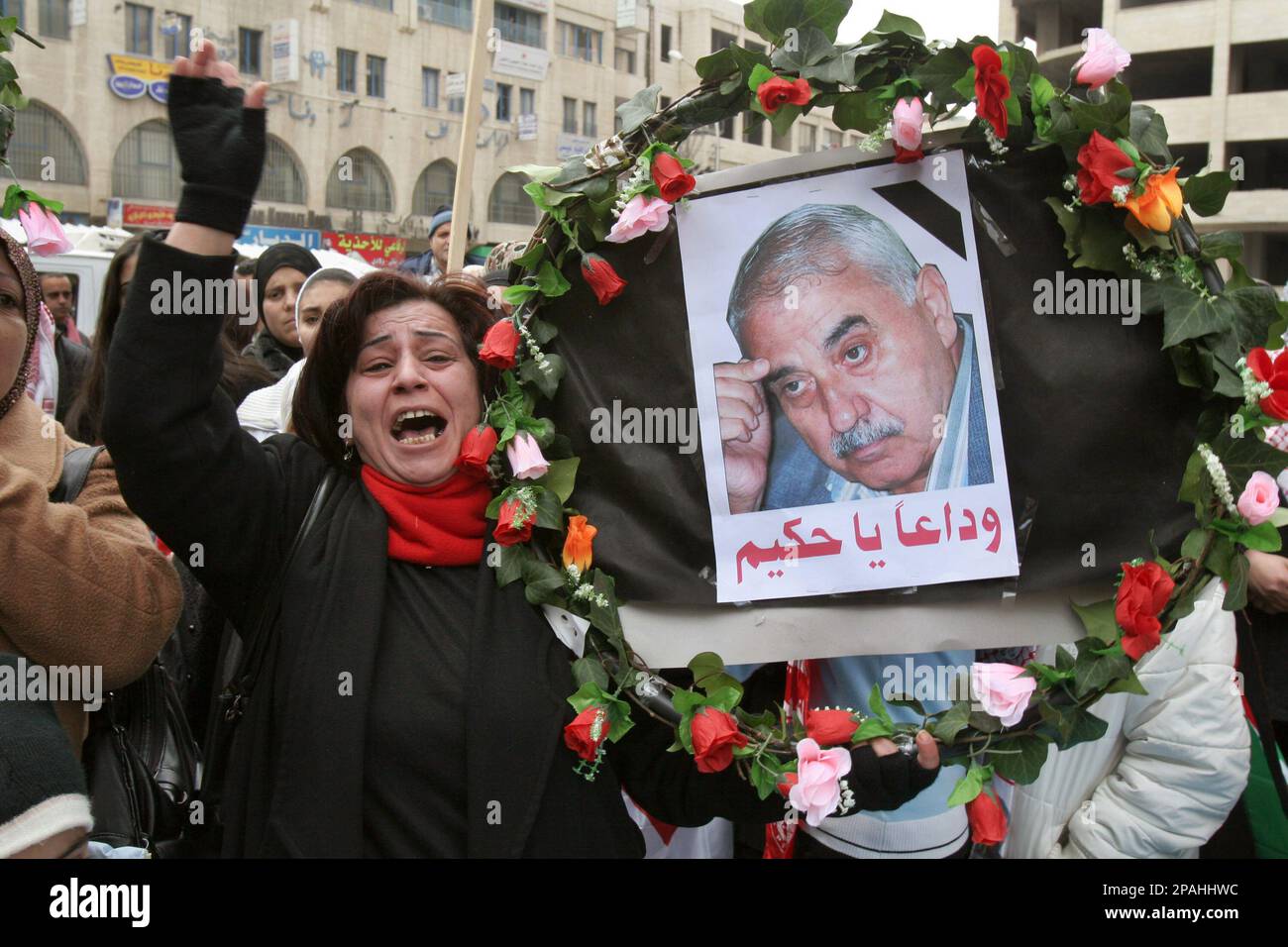 A Palestinian woman, holds a portrait of George Habash, the founder of ...