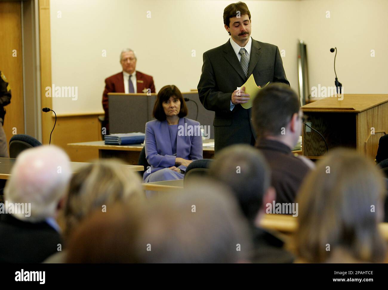 William Flynn, standing center, cries as he addresses the Smart family ...