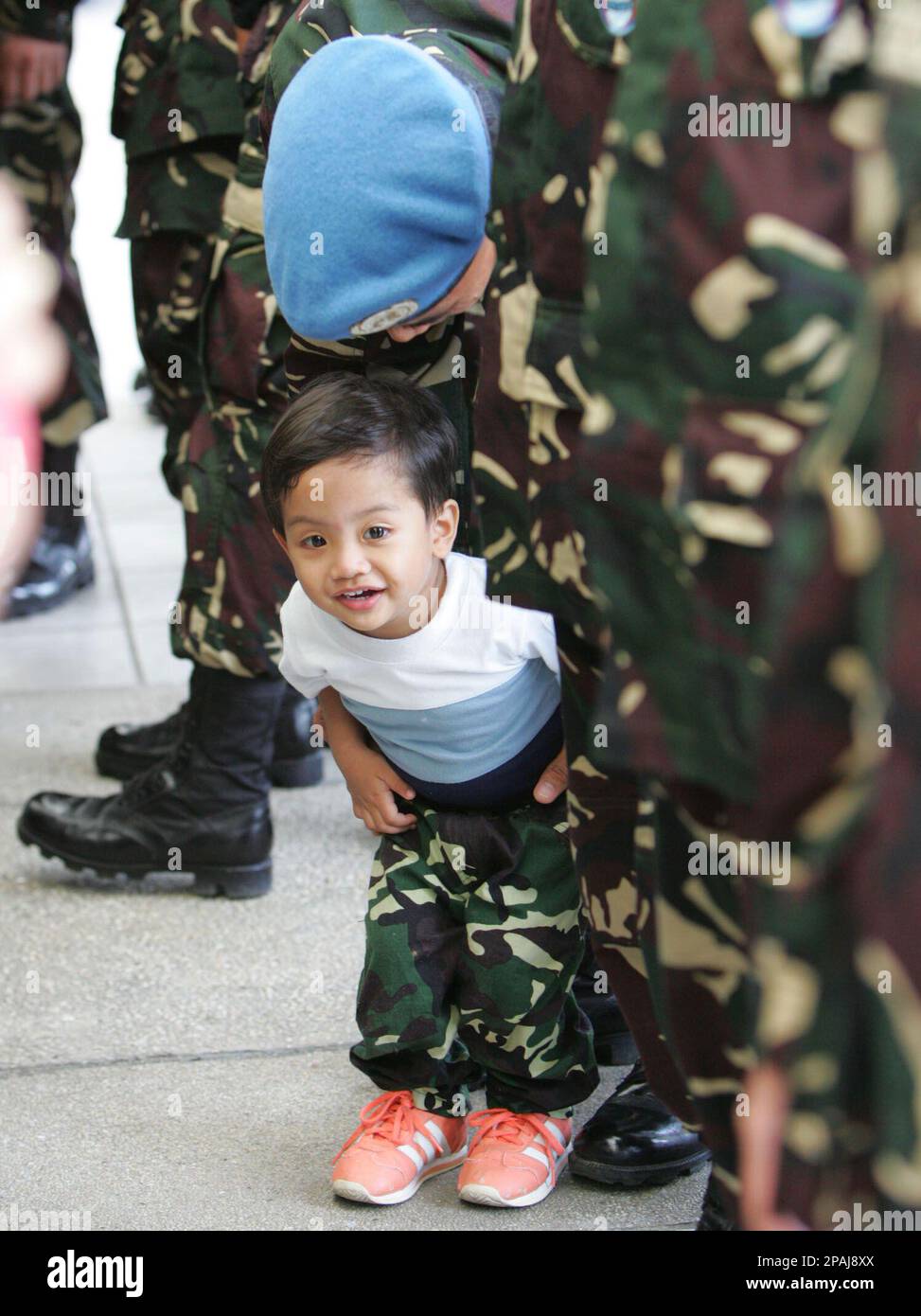 A Philippine soldier attends to his son while in formation during the ...