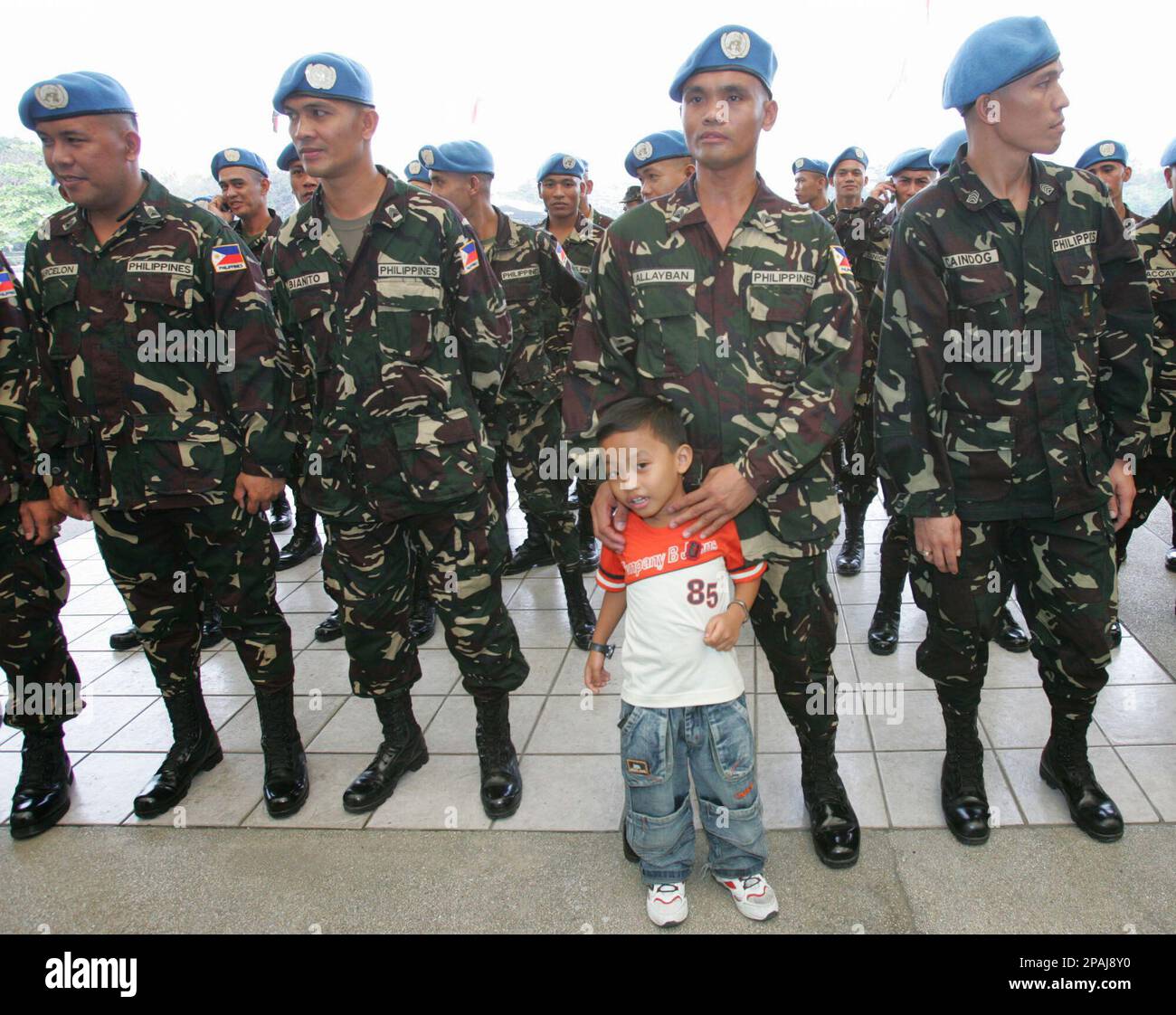 A Philippine soldier attends to his son before their departure during ...