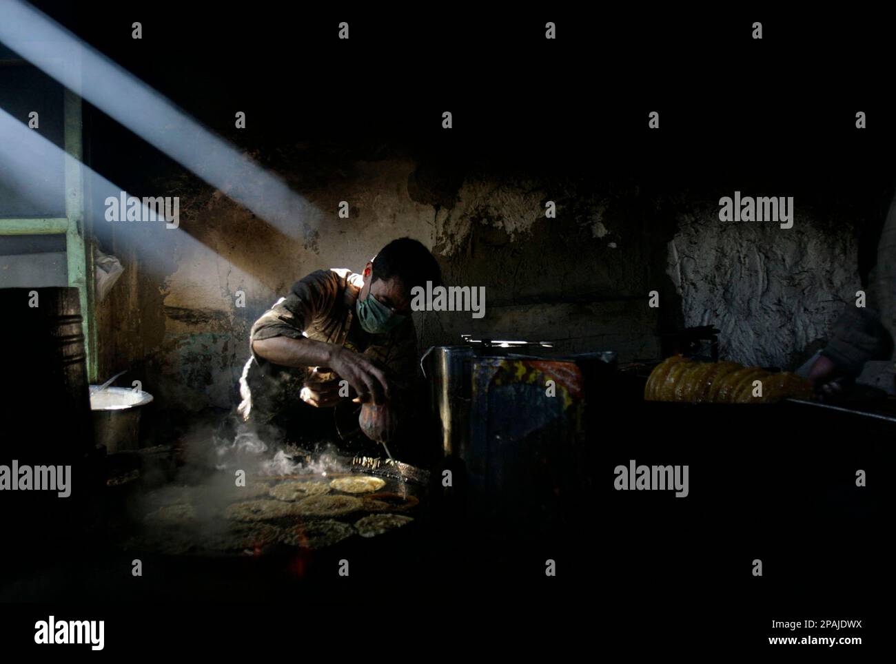Javid Ahmad, an Afghan man, makes sweets at his shop in the downtown ...