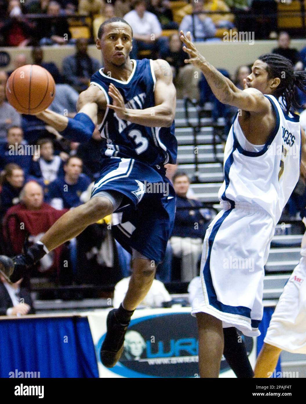 Xavier's Stanley Burrell, left, passes the ball as George Washington's ...