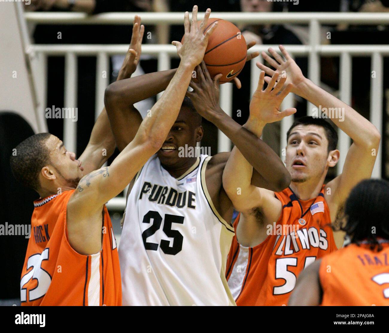 Purdue's JaJuan Johnson, center, gets tied up with Illinois' Mike ...