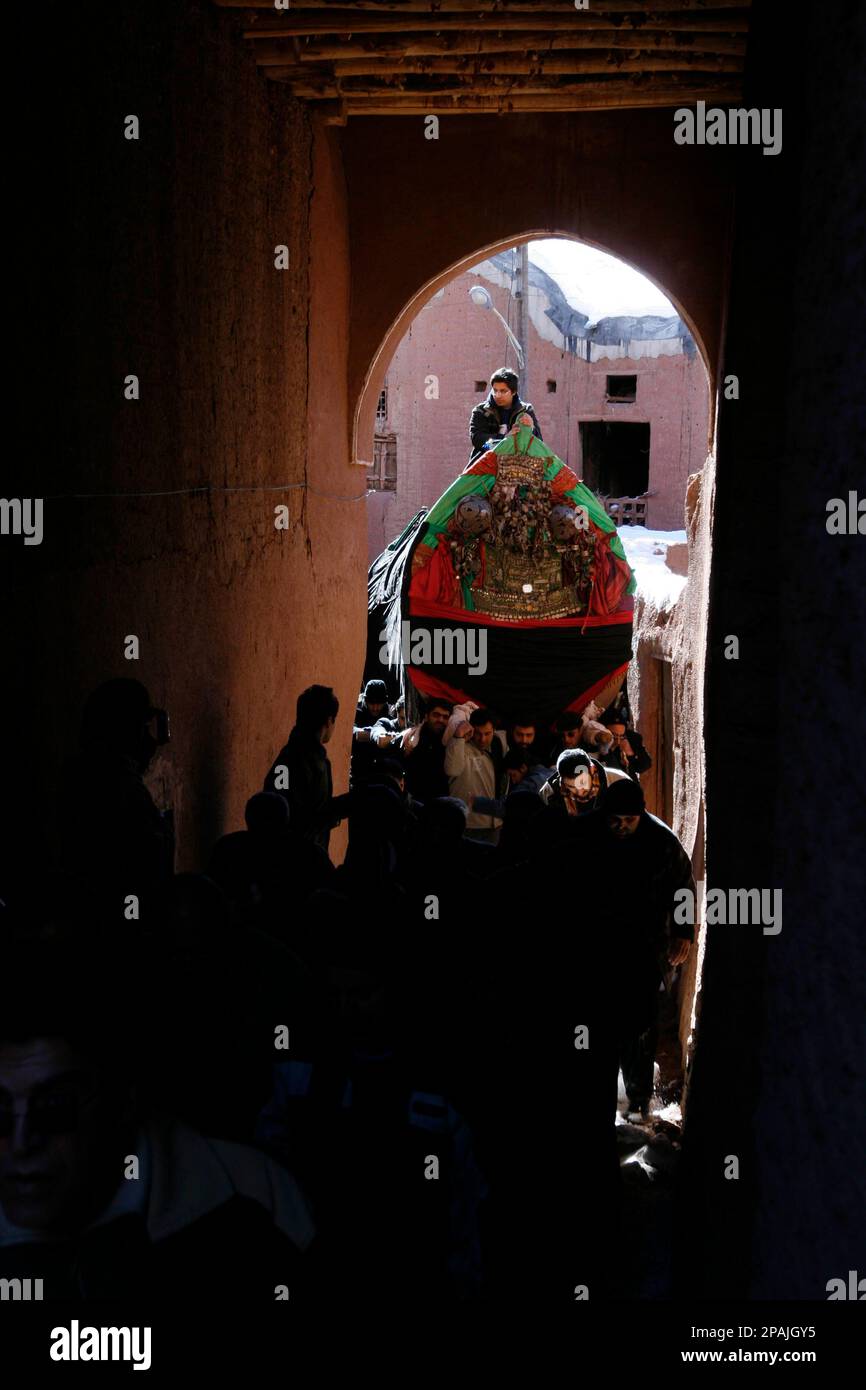 Iranian men carry a funeral litter representing one containing the body ...