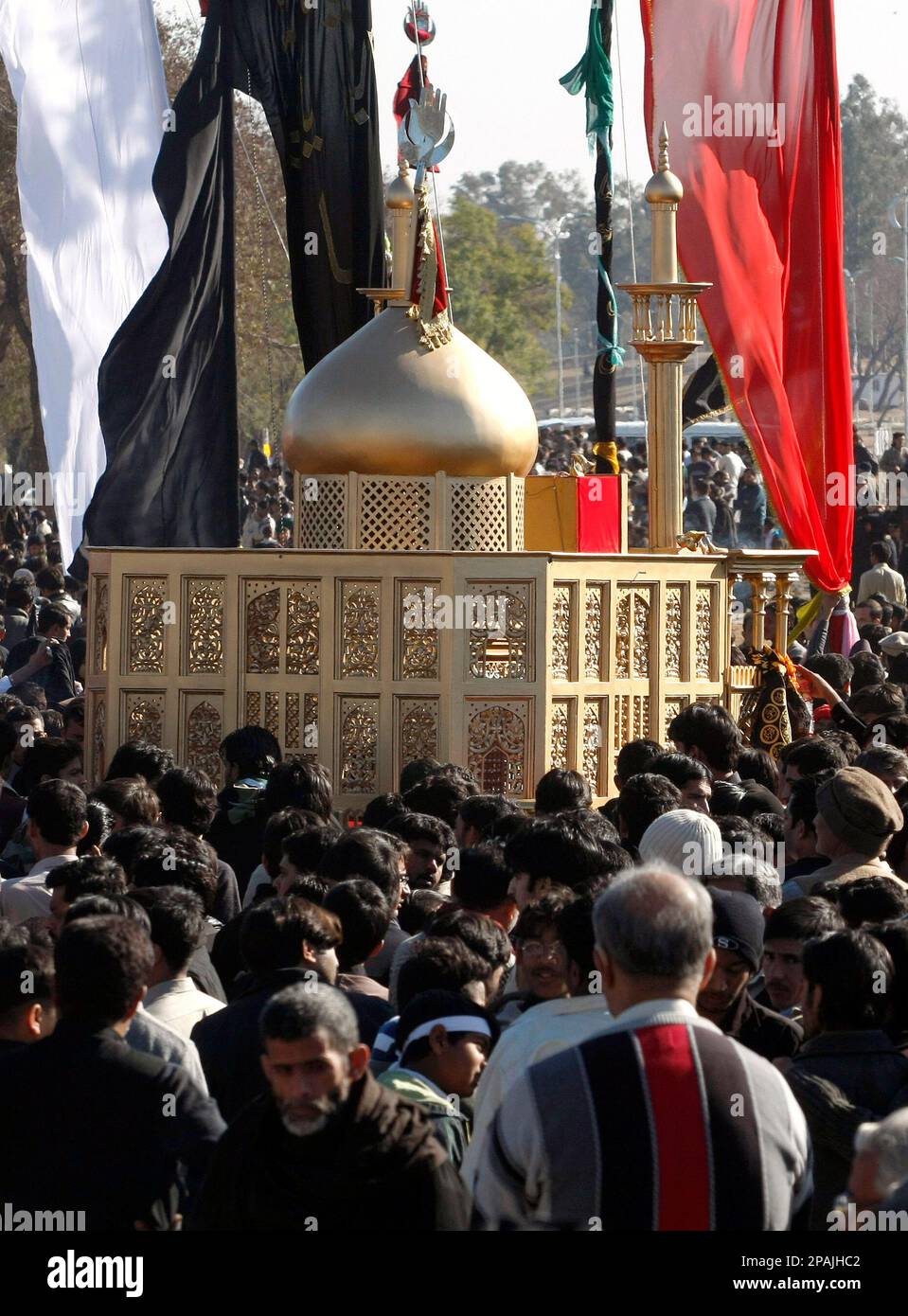 Pakistani Shiite Muslims touch a replica of the shrine of their ...