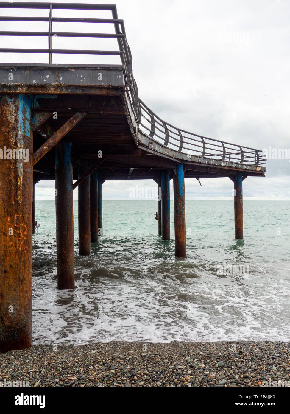 Metal pier on columns. Construction on the sea.Rusty pier. Resort place ...
