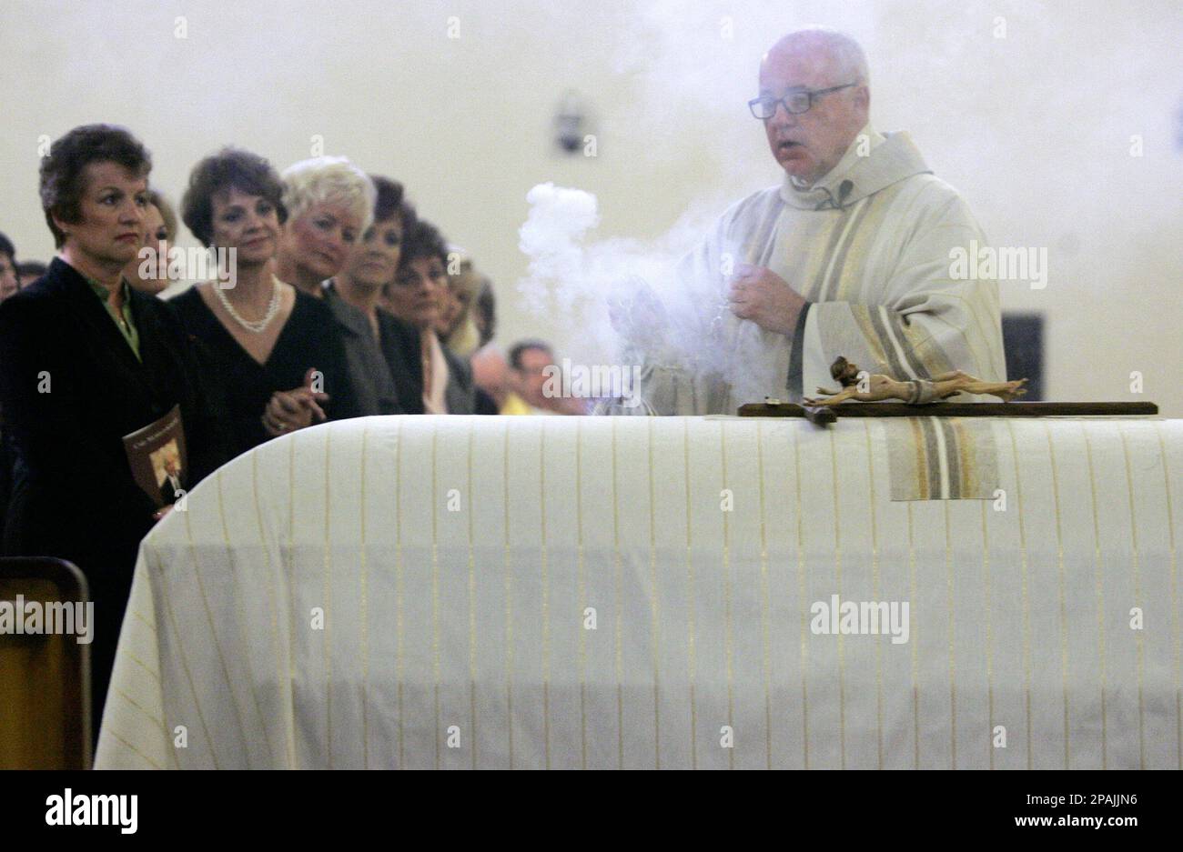 Father Jerome Thomas Karcher, right, son of Carl Karcher burns incense ...
