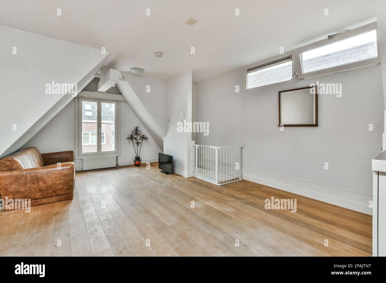 a living room with hardwood flooring and white walls in an attic style ...