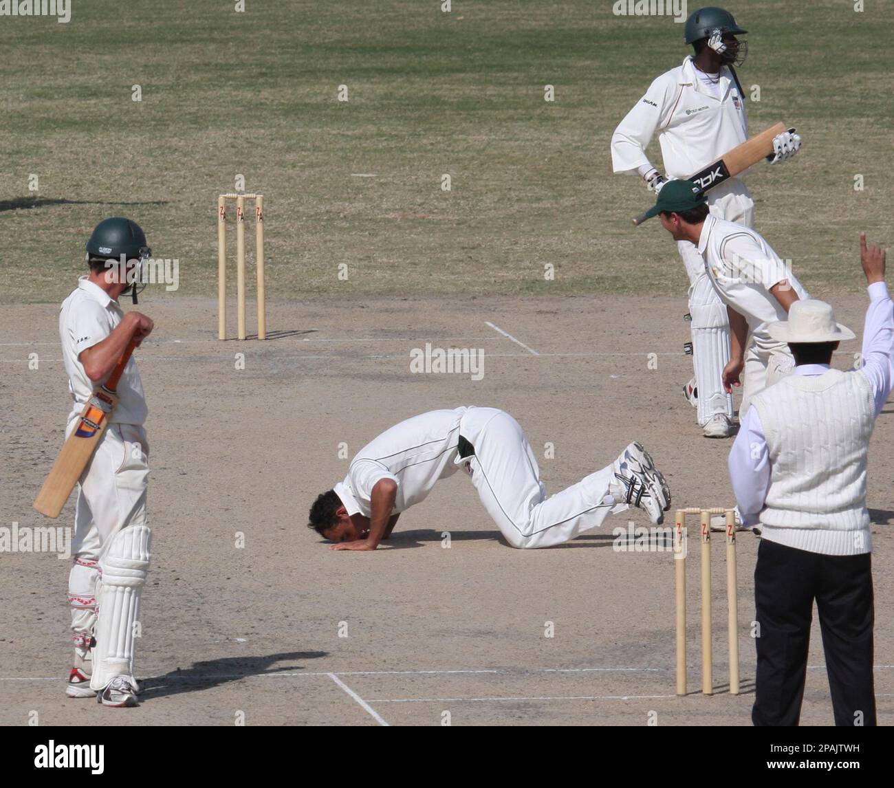 Pakistan's bowler Samiullah Niazi kisses a pitch as he dismisses ...