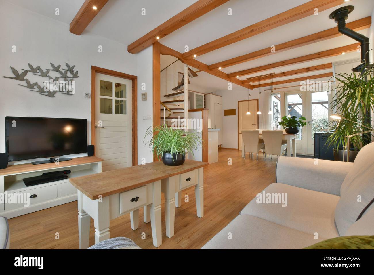 a living room with wood beams on the ceiling and white couches in front ...