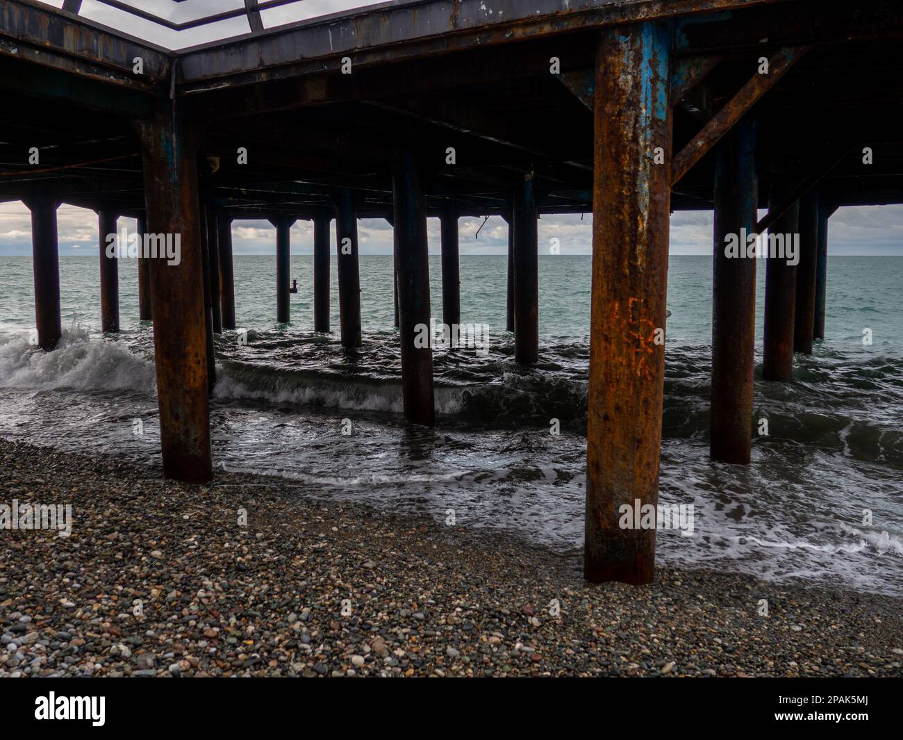 Metal pier on columns. Construction on the sea.Rusty pier. Resort place ...