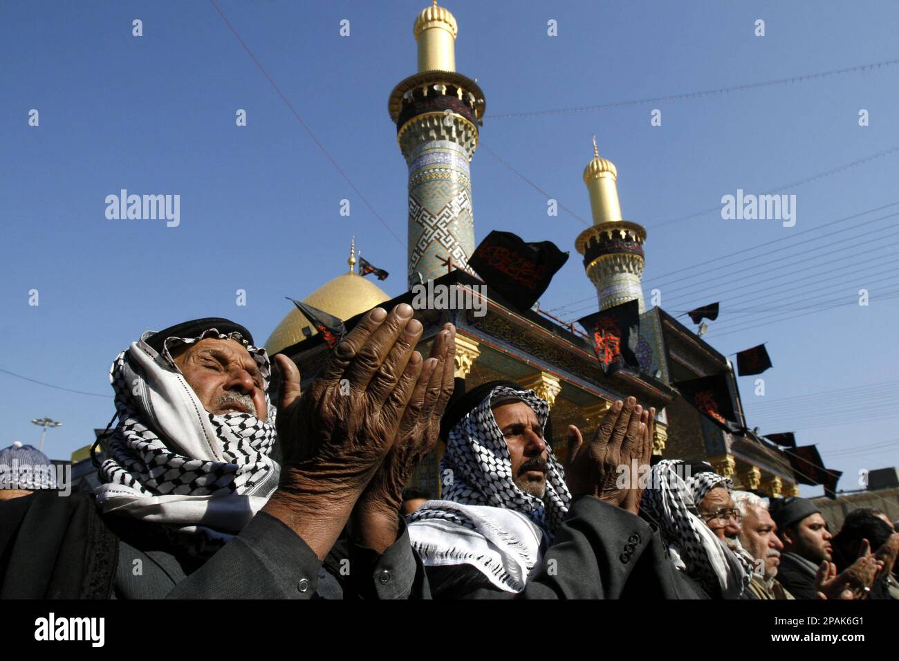 Iraqis attend prayer in front of the Imam Abbas shrine in the Shiite ...