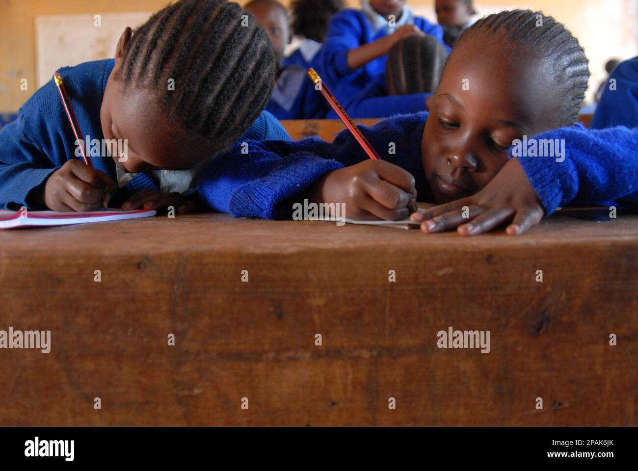 Children write in a classroom at the Olympic School in the Kibera slum ...