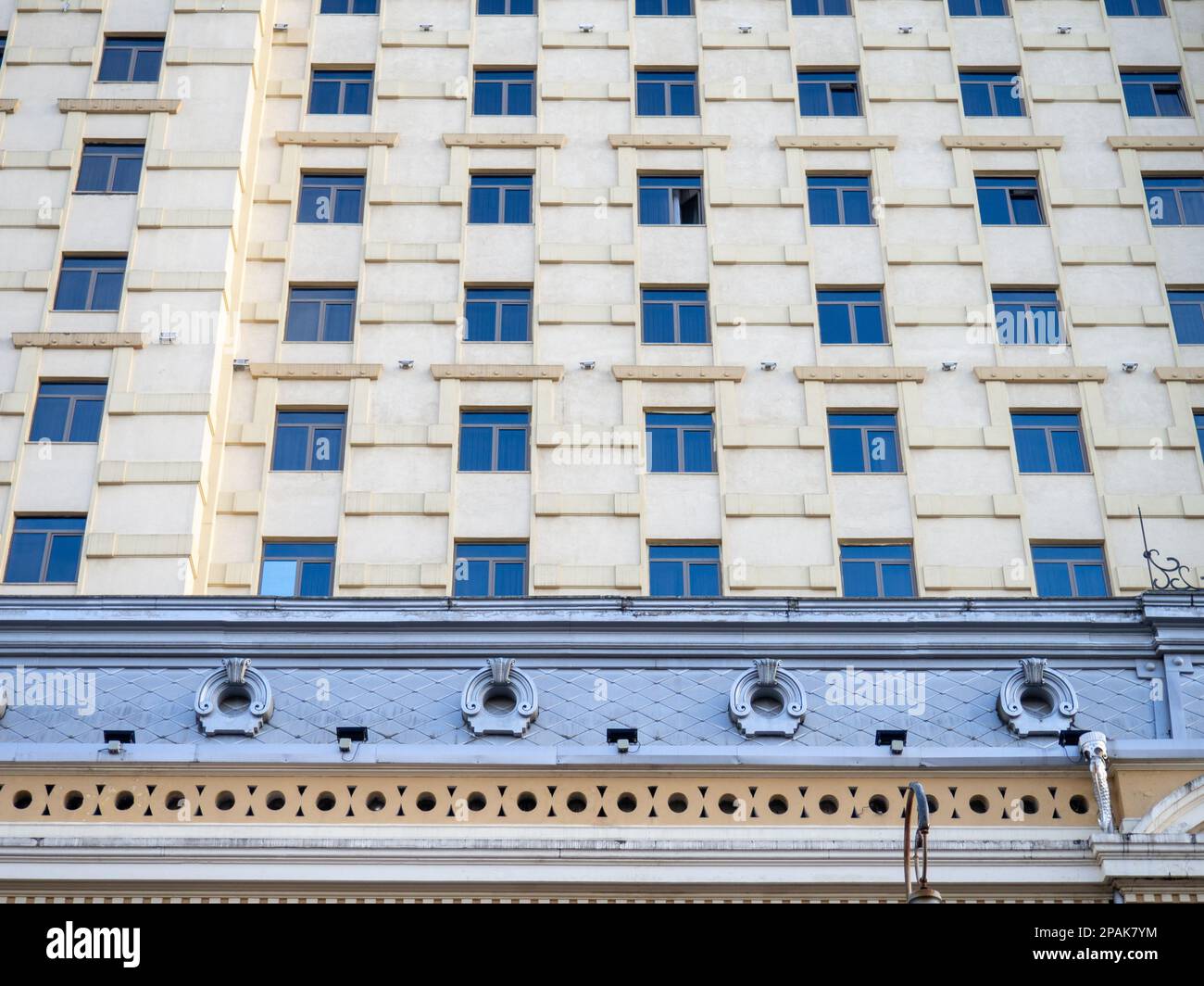 Building's facade. Background from many windows. View from below on a tall building. Hotel in ...