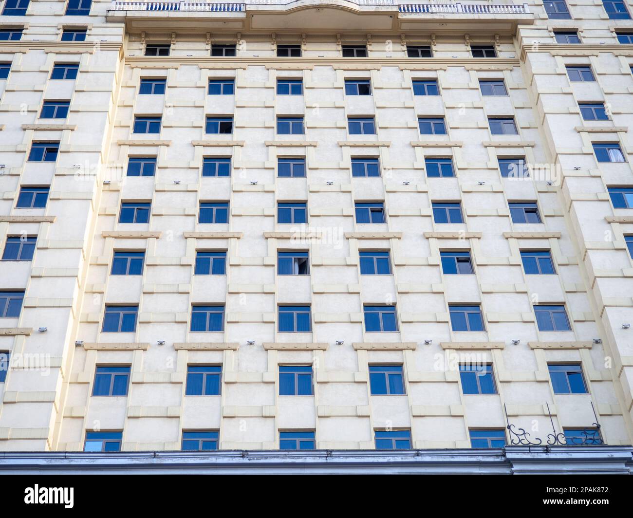 Building's facade. Background from many windows. View from below on a tall building. Hotel in ...