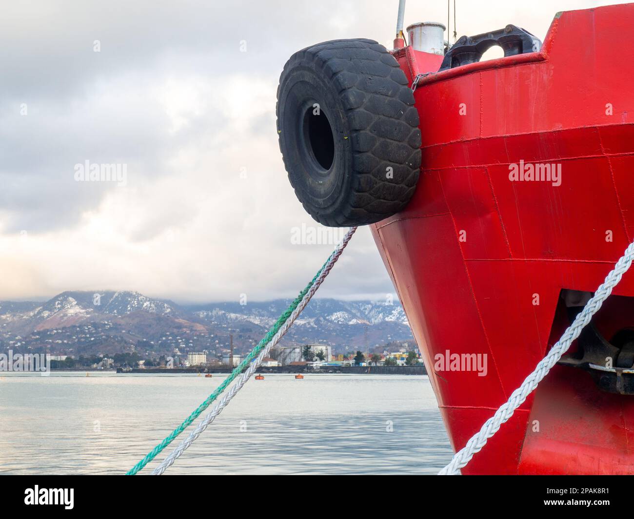 nose of the ship is red. Tire on the bow of the ship. Safety . Moored ...