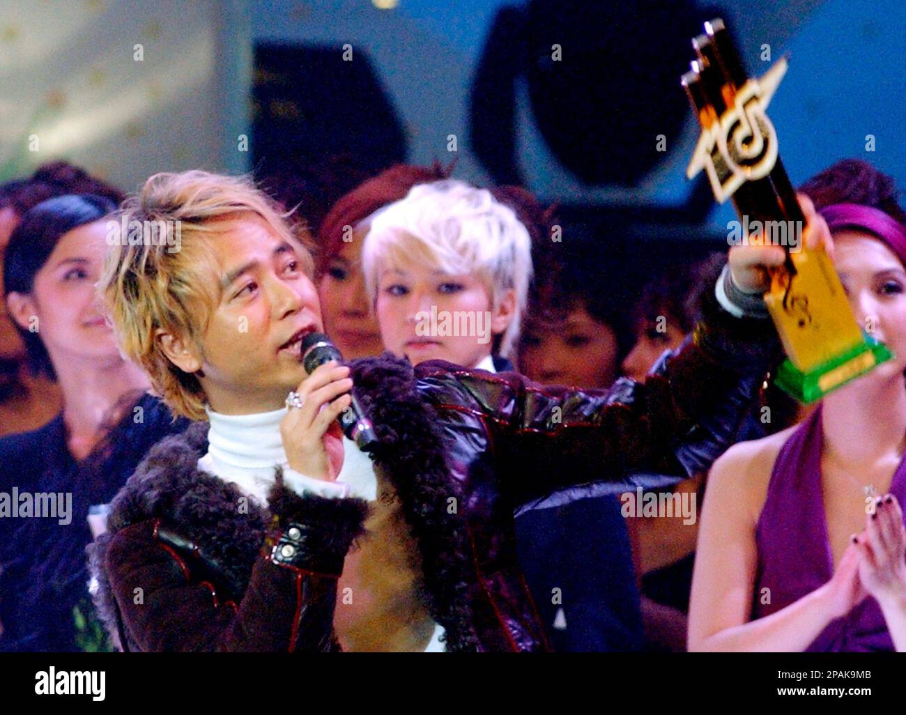 Hong Kong singer Hacken Lee holds the trophy after awarded the Best ...