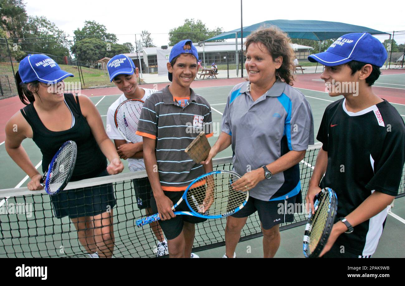 A group of children gather around Australian tennis legend Evonne Goolagong, 2nd right, at a ...