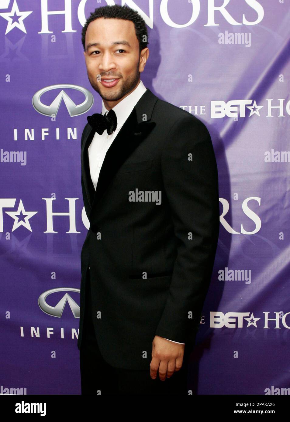Singer John Legend stands on the red carpet after arriving for the BET ...