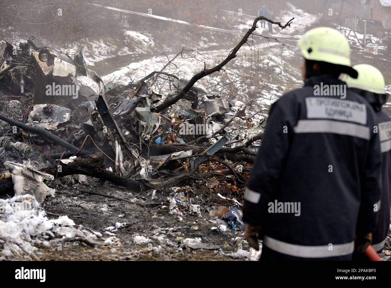 Firefighters look at the helicopter debris at the site of a crash near ...