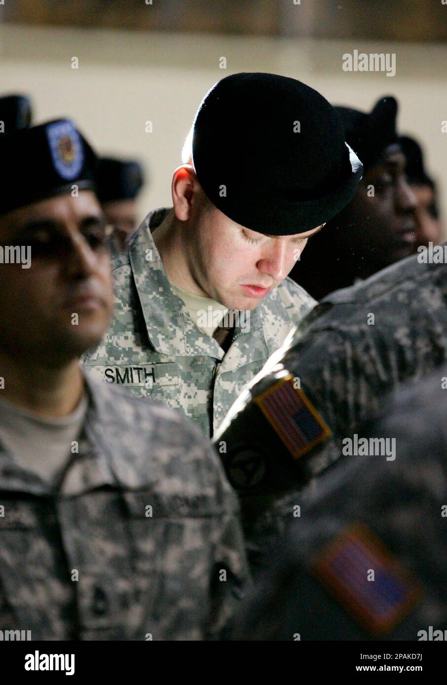 Army Specialist Ryan Smith bows his head momentarily during a ...