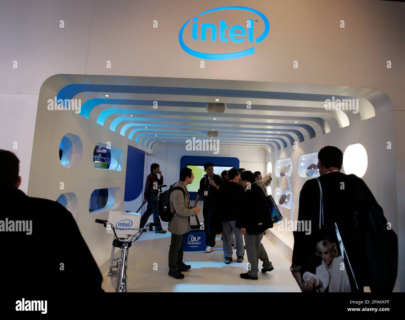 Attendees look at the Intel booth showing computer wafer chips on ...