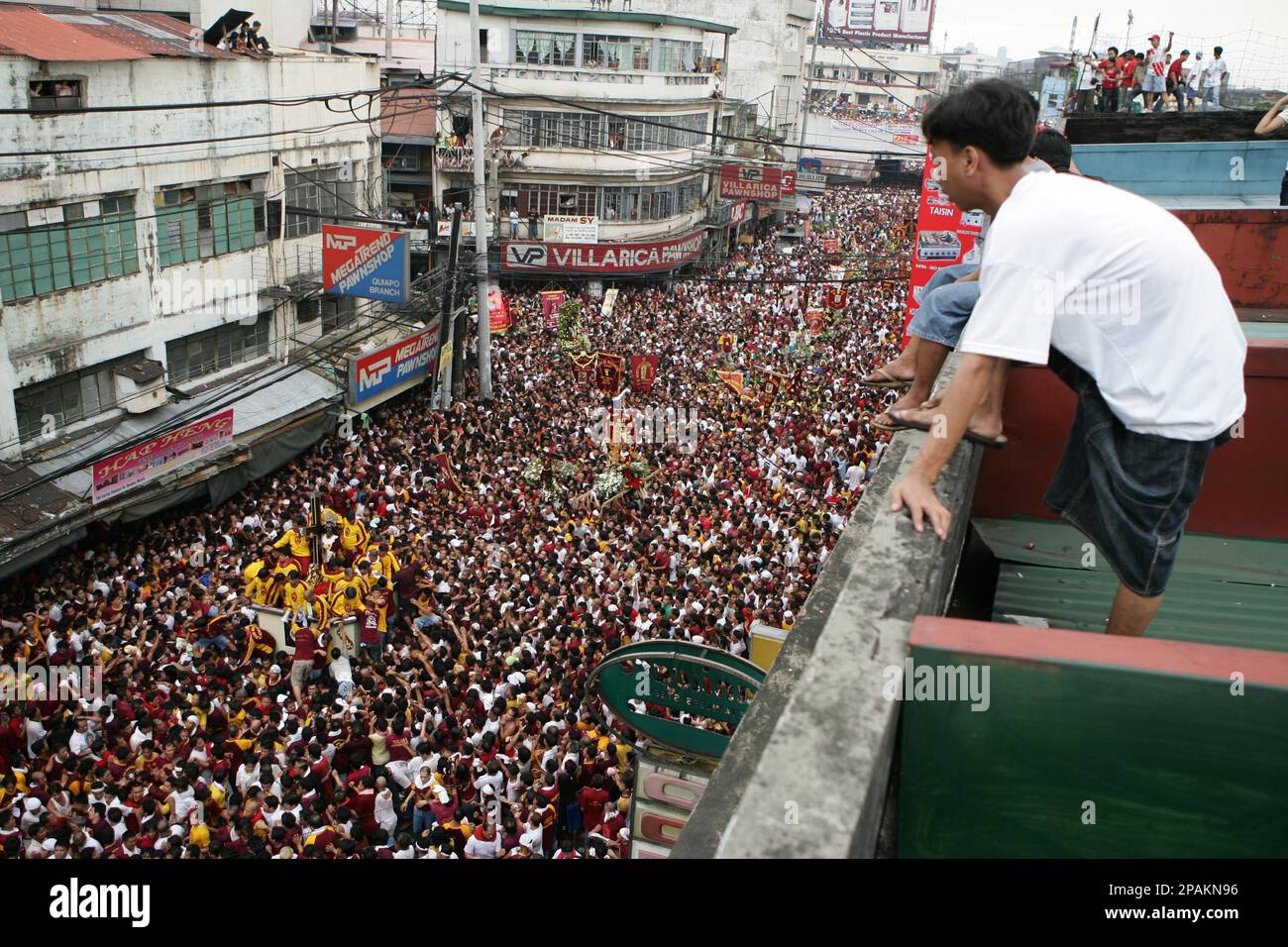 A crowd watches as tens of thousands of devotees jostle to touch the ...
