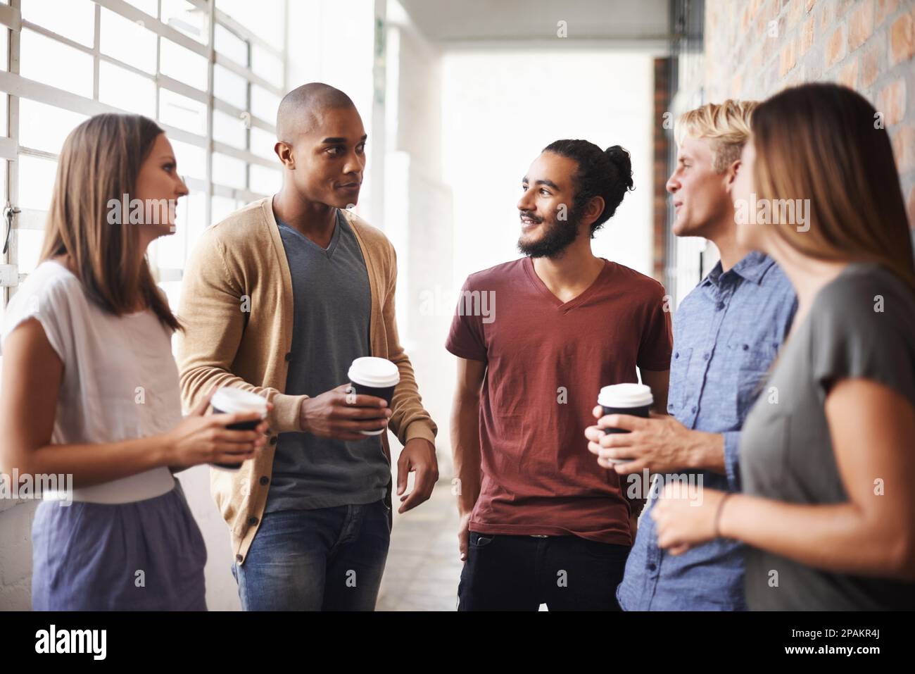 Grabbing some coffee with a few colleagues. a diverse group of friends ...