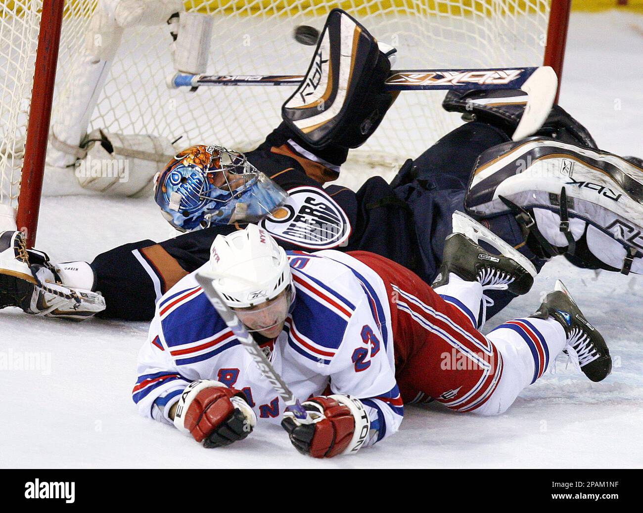 New York Rangers' Chris Drury, right, runs over Edmonton Oilers goalie ...