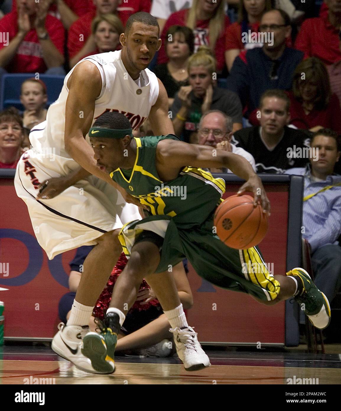 Oregon's Tajuan Porter (12) tries to dribble pass the pressing defense ...