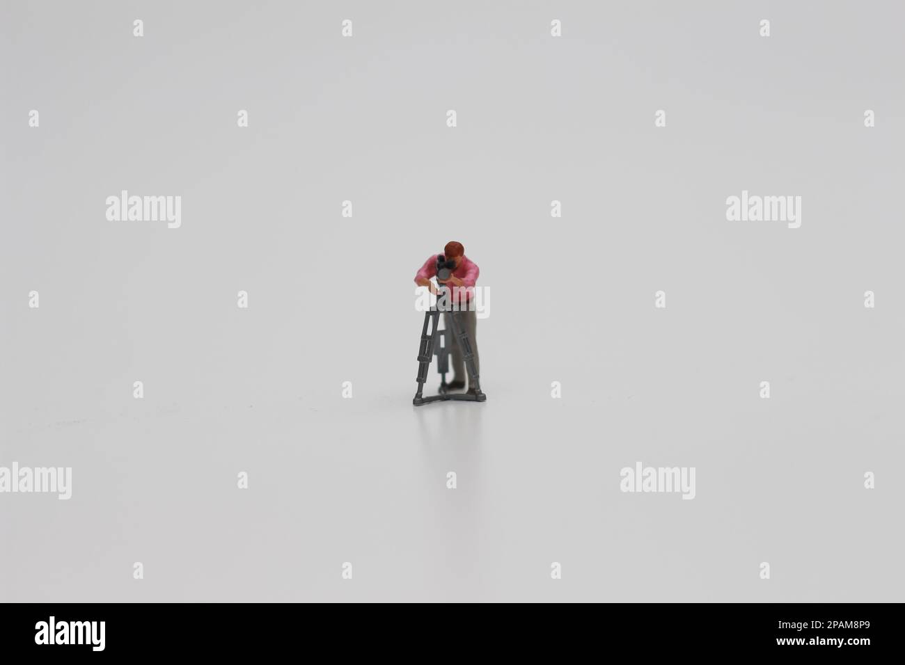a close up of miniature figure of a videographer isolated on white ...