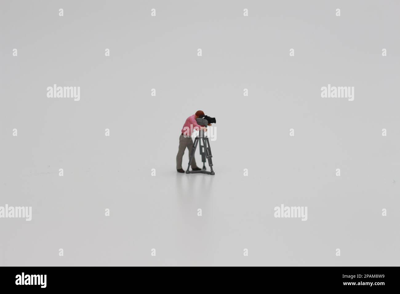 a close up of miniature figure of a videographer isolated on white ...