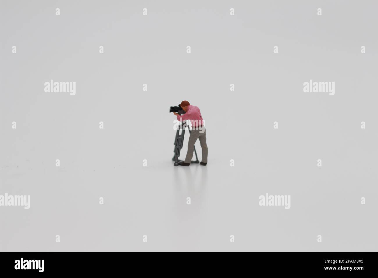 a close up of miniature figure of a videographer isolated on white ...