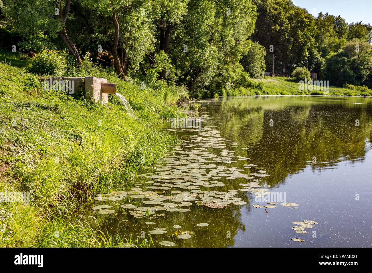 Drain water from the pipe into the river Stock Photo - Alamy