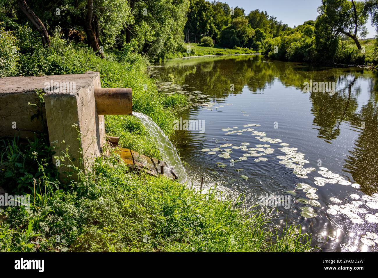 Drain water from the pipe into the river Stock Photo - Alamy