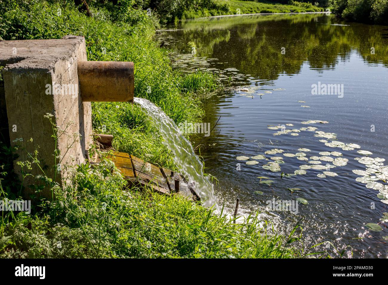 Drain water from the pipe into the river Stock Photo - Alamy