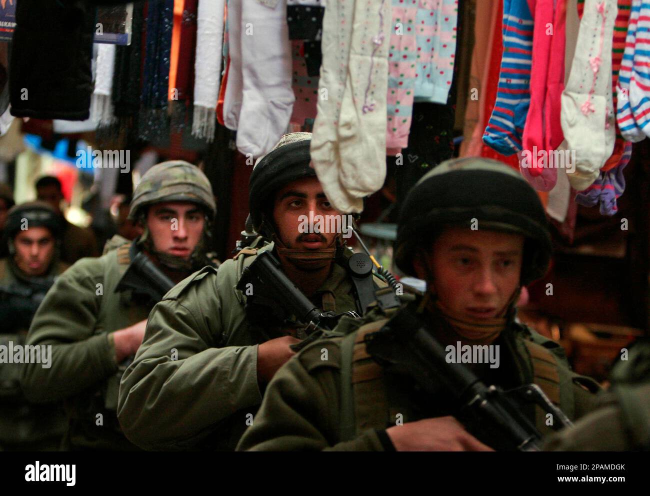 Israeli soldiers walk in the Palestinian market area during a routine ...