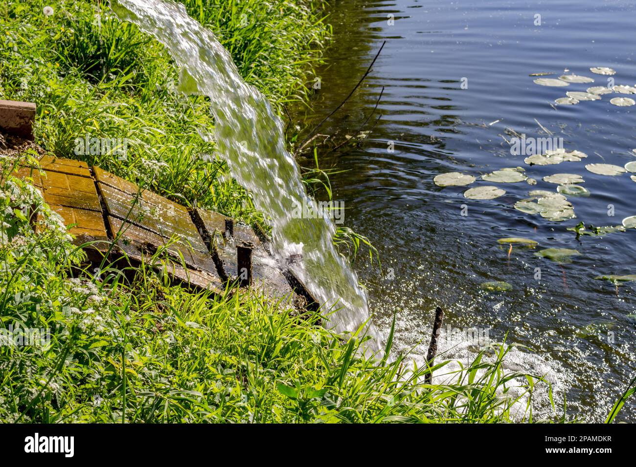 Drain water from the pipe into the river Stock Photo - Alamy