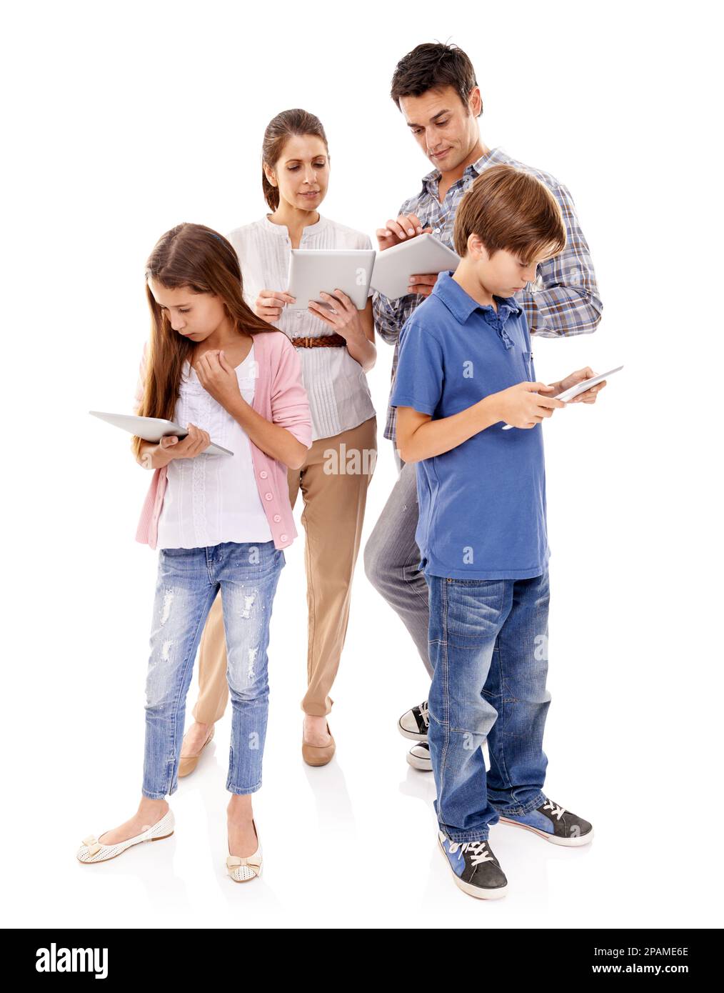 Immersed in the online world. A family of four all using tablets while ...